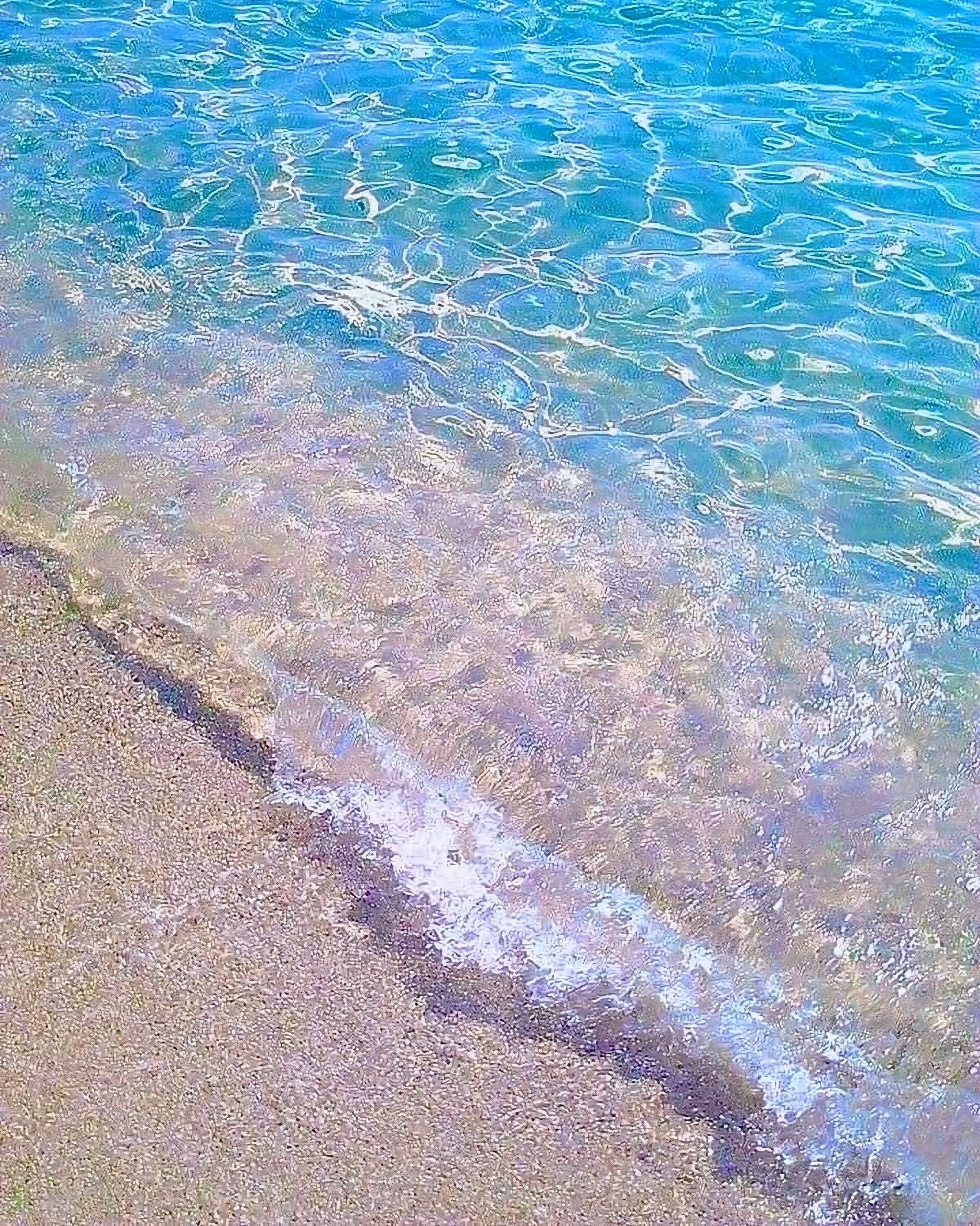 Uma praia com águas cristalinas e areal arenoso.