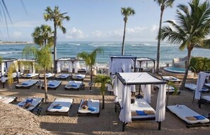 Um resort à beira-mar com vários espreguiçadeiras e área de piscina.