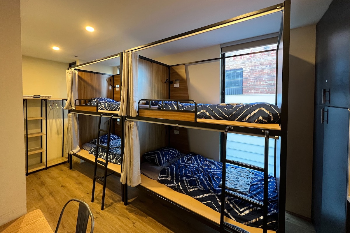 Quarto com beliche, uma escrivaninha e um guarda-roupa.