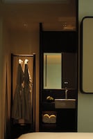 Casa de banho de hotel com banheira, espelho e lavatório.