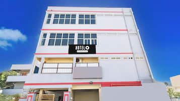 Um edifício com vários andares e uma placa indicando que é um hotel.