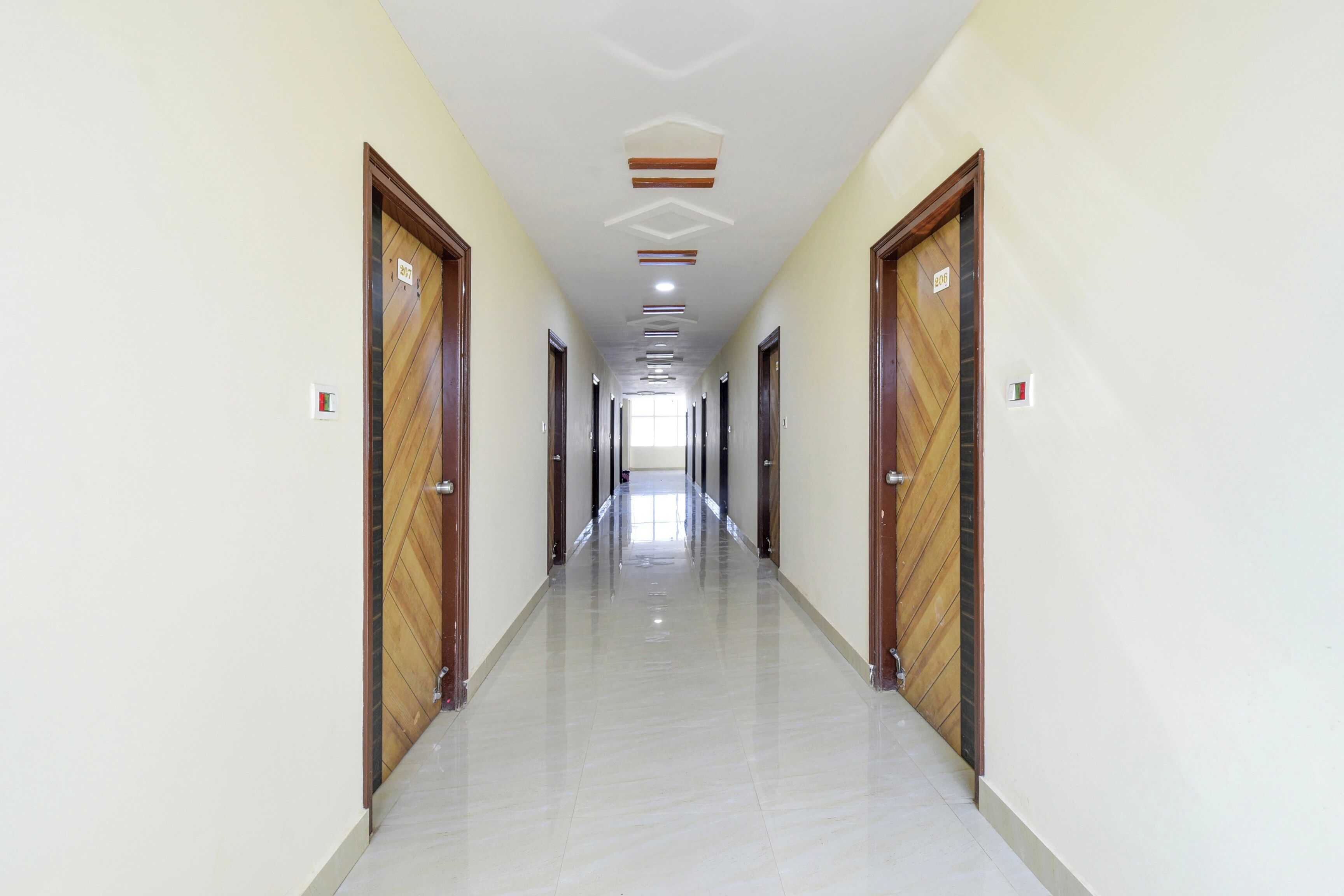 Um corredor comprido e estreito, com portas de ambos os lados, que dá acesso a quartos individuais.