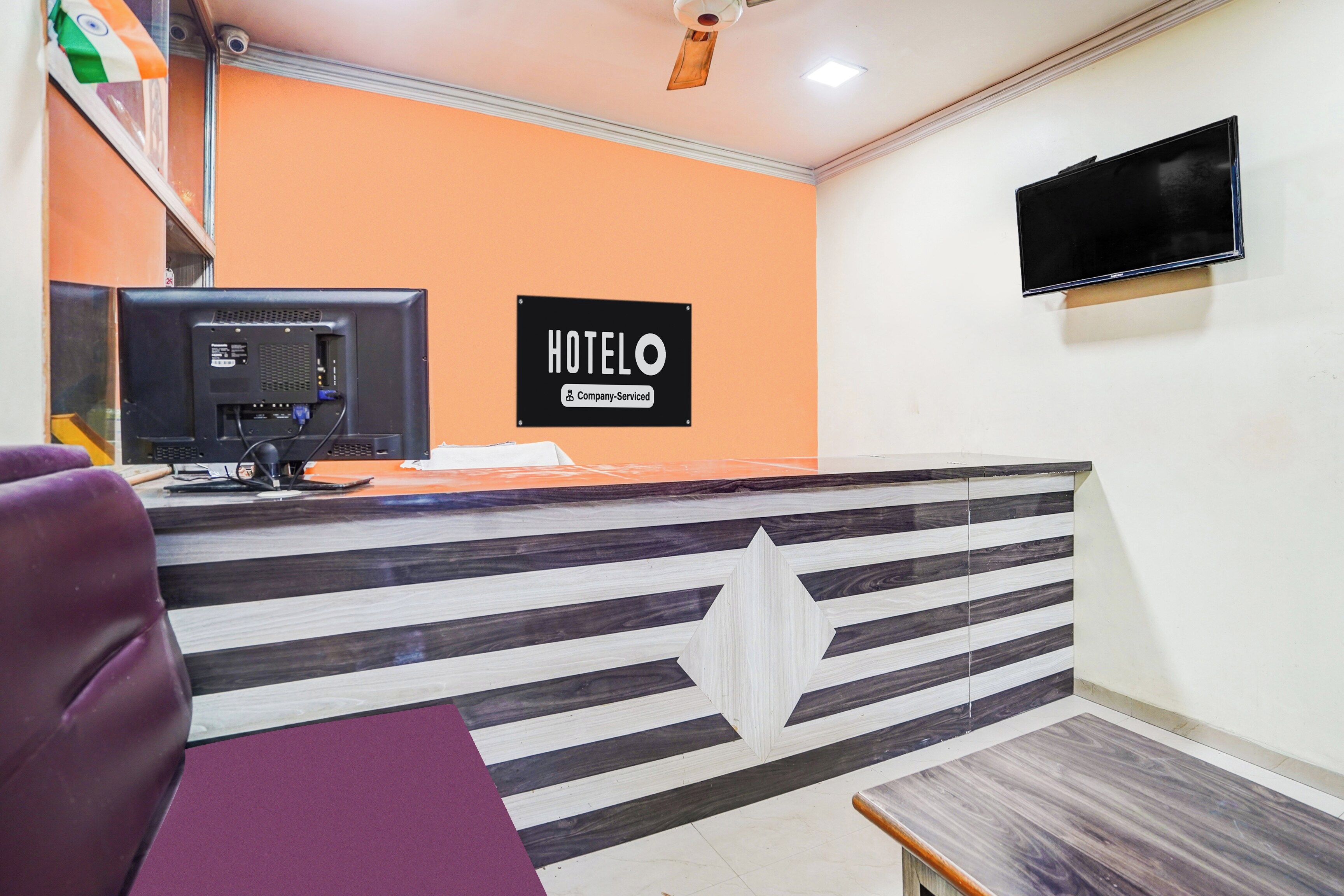 Balcão de recepção de hotel com uma placa indicando que é um hotel de serviço corporativo.