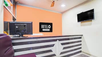 Balcão de recepção de hotel com uma placa indicando que é um hotel de serviço corporativo.