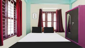 Um quarto com cama, guarda-roupa e janela com cortinas.