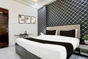 Quarto moderno com cama, mesa de cabeceira, prateleira na parede e painel decorativo.