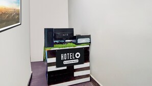 Balcão de recepção com uma placa indicando 'HOTELO Company-Serviced' em um corredor.