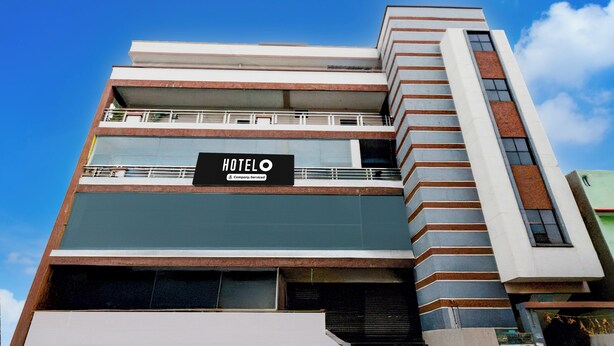 Um hotel com vários andares e um grande letreiro 'HOTEL' na fachada.