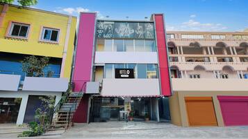 Um edifício de vários andares com um letreiro grande escrito 'HOTEL' no andar térreo.
