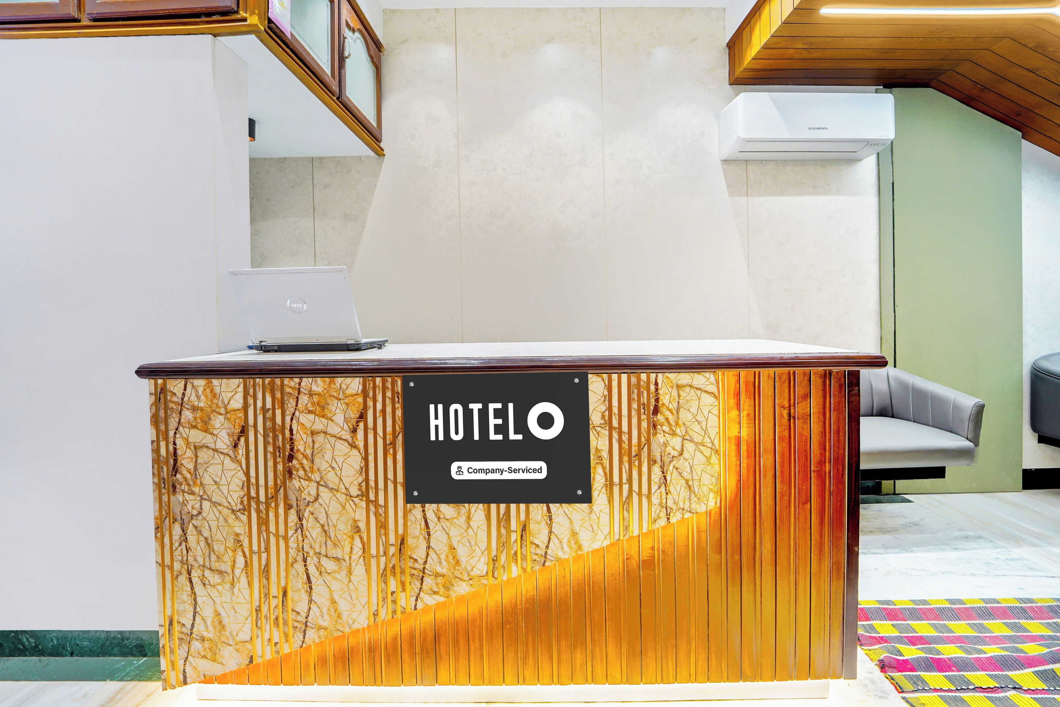 Balcão de recepção com placa indicando que é um hotel de serviço empresarial.