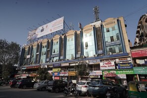 Um edifício de vários andares com letreiros comerciais, incluindo uma farmácia e um centro de aparelhos auditivos.