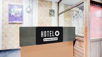 Balcão de recepção de hotel com aviso indicando serviço da empresa.