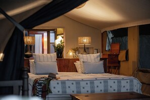Um quarto aconchegante com uma cama, duas luminárias de cabeceira, um criado-mudo, um penteadeira e um espelho.