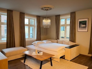 Quarto de hotel com uma cama, mesa de cabeceira e vista para o exterior.
