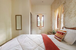 Quarto com cama, janela com cortinas, espelho e porta.