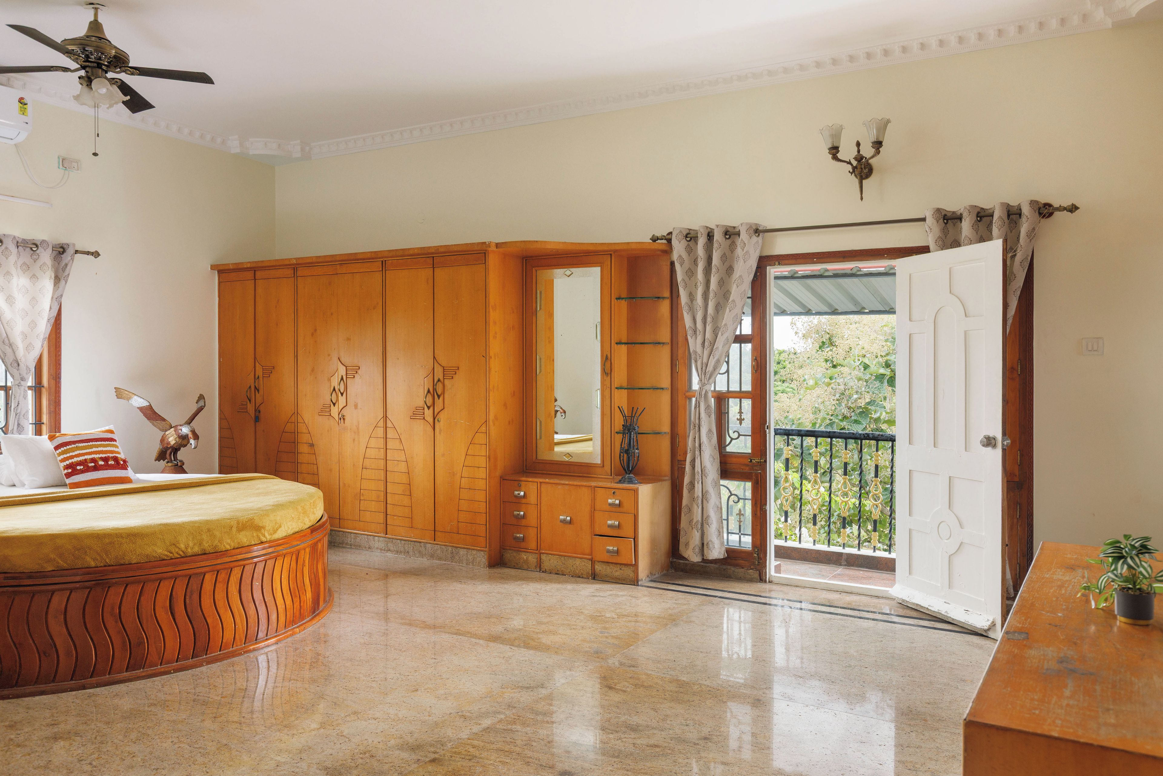 Quarto com cama, guarda-roupa, penteadeira e espelho.