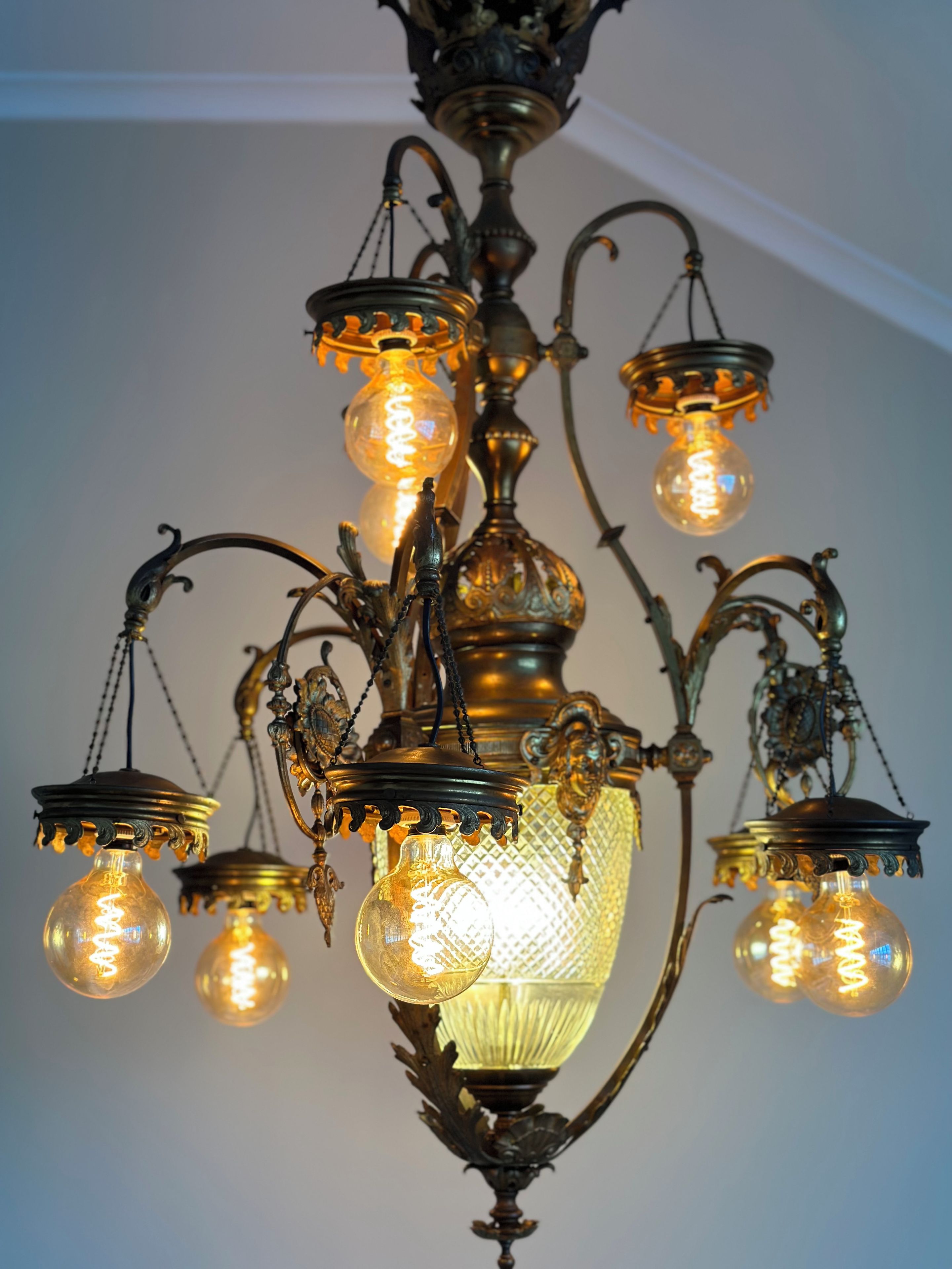 Um candelabro com várias lâmpadas e detalhes em metal ornamental.