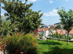 Zona residencial com vista clara para casas, uma estátua e vegetação exuberante.