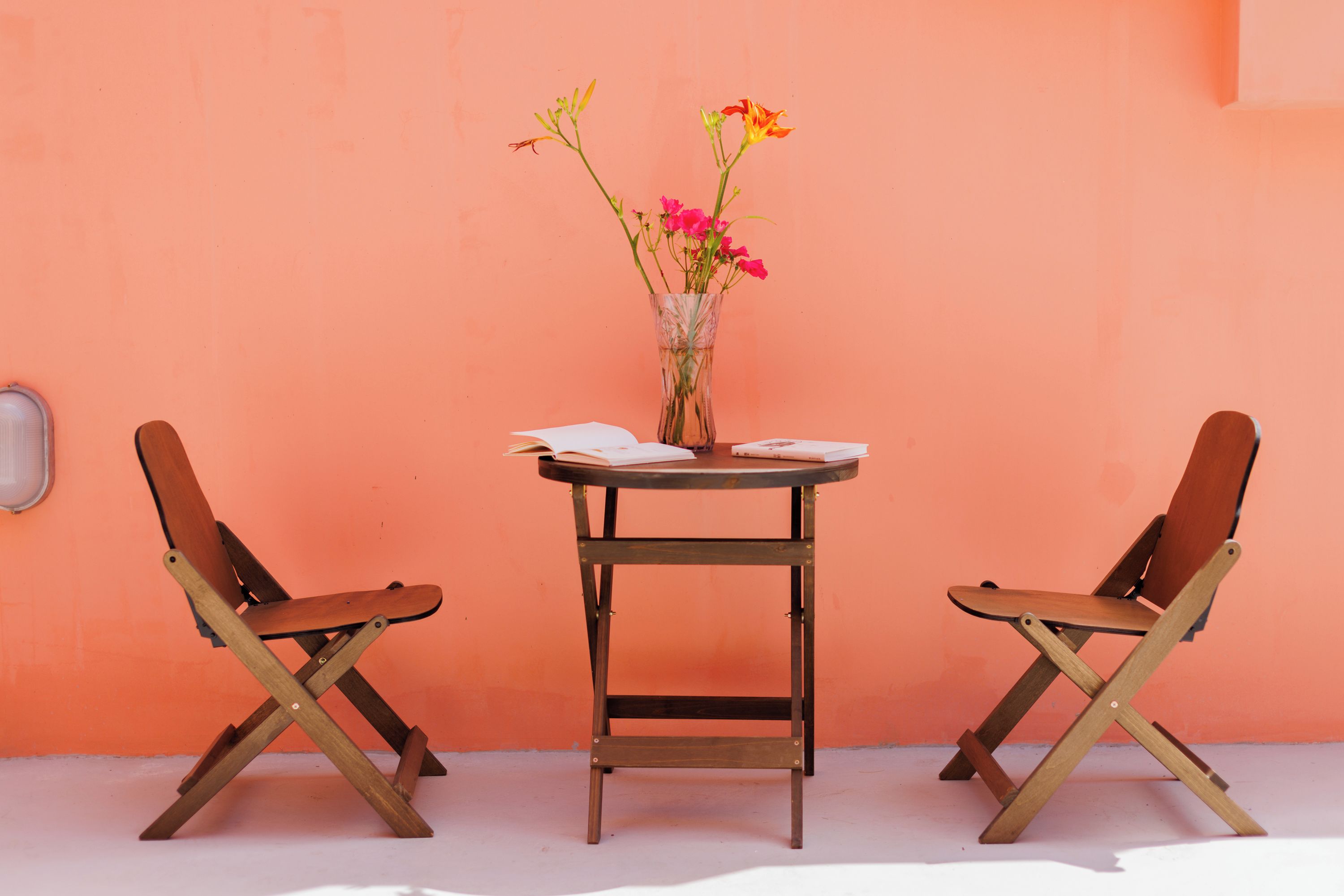 Uma mesa com duas cadeiras e um vaso de flores.
