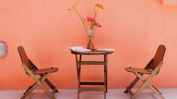 Uma mesa com duas cadeiras e um vaso de flores.