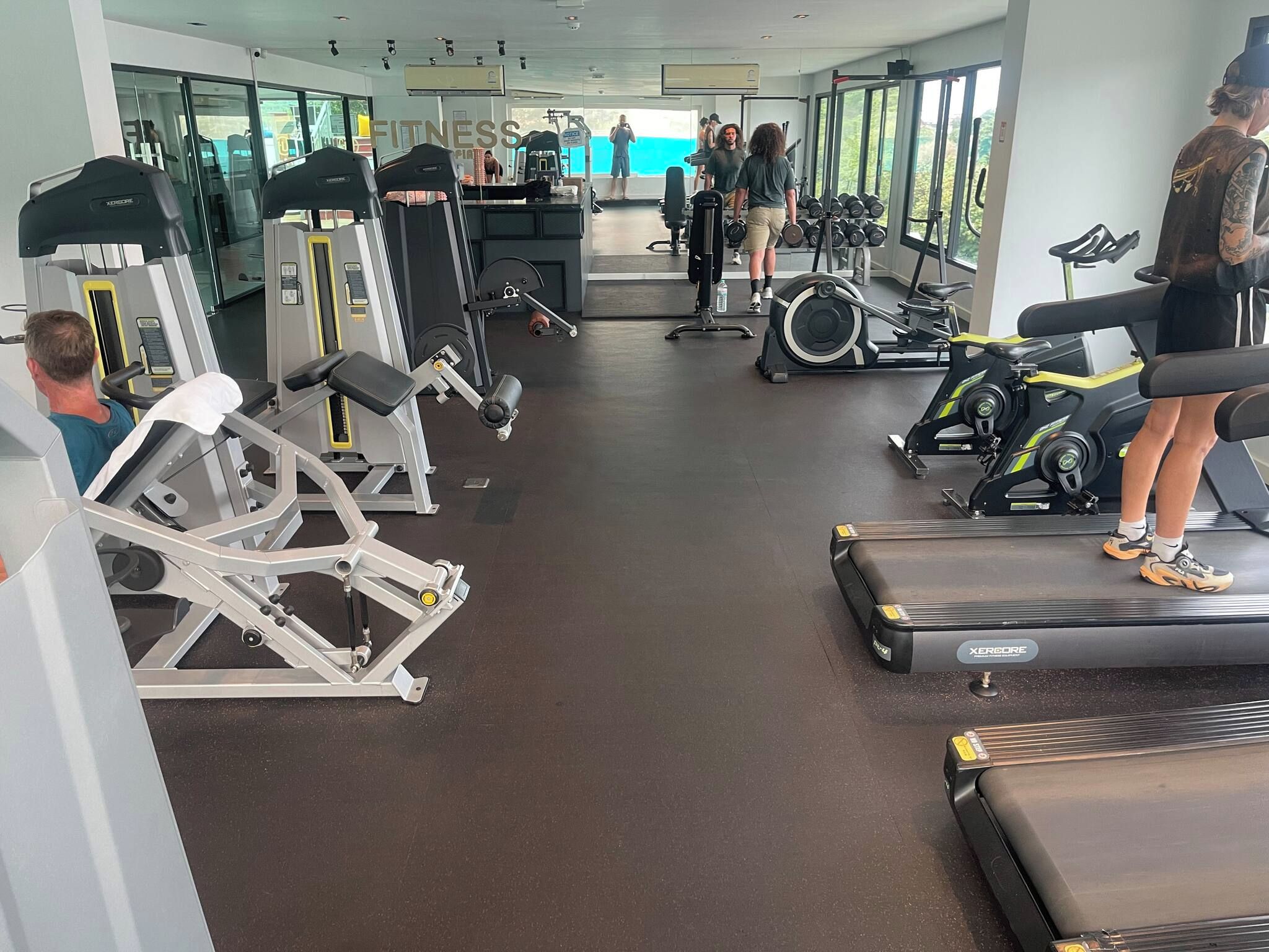 Academia com esteiras, bicicletas ergométricas e aparelhos de musculação.