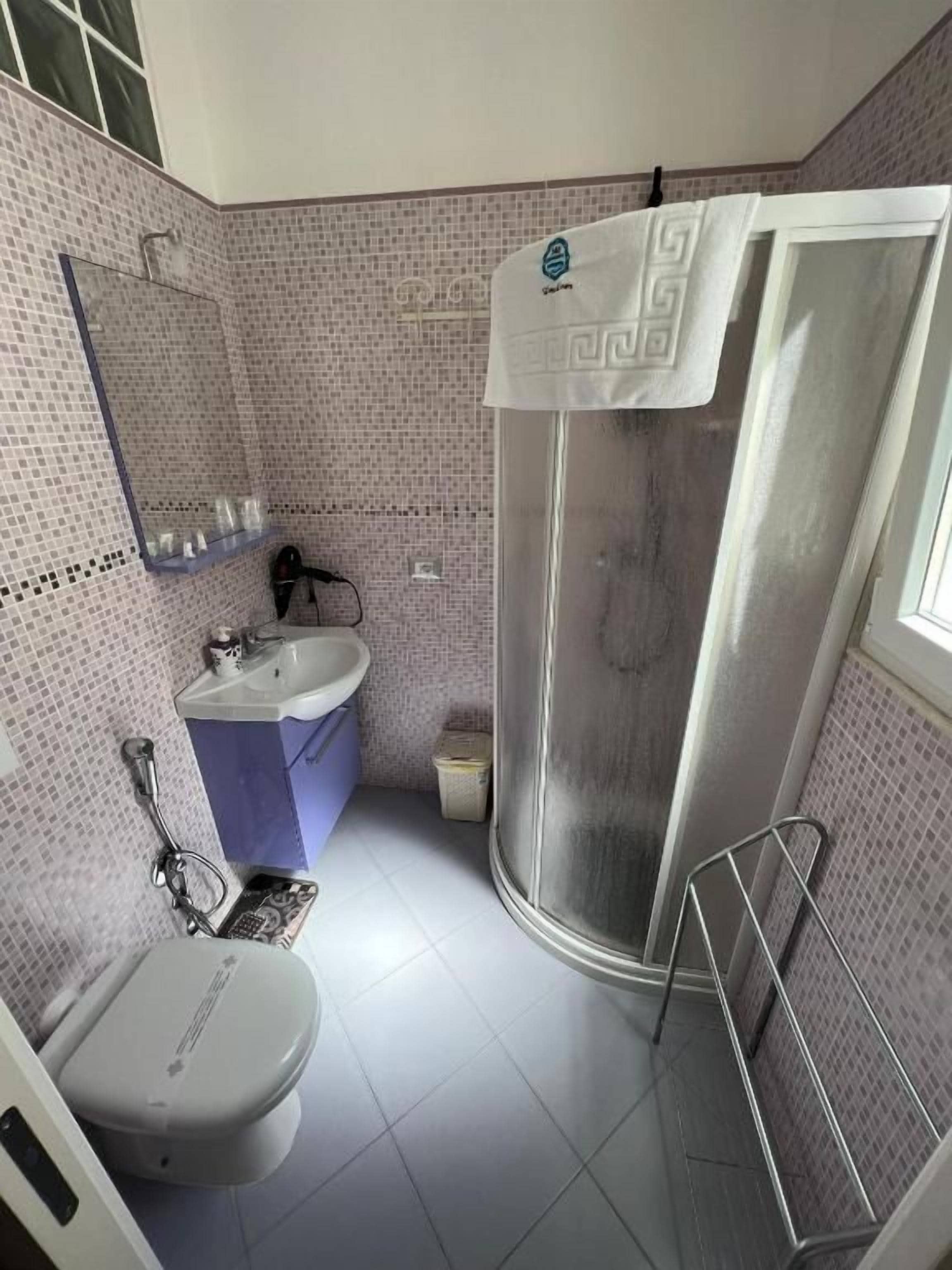 Casa de banho com sanita, lavatório e zona de duche.
