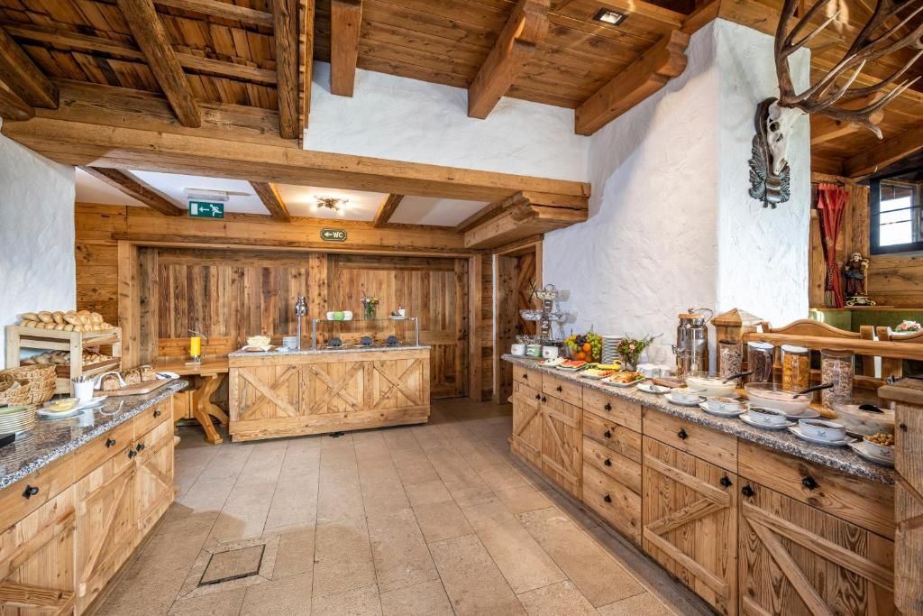 Cozinha rústica com armários de madeira, uma ilha central e teto com vigas aparentes.