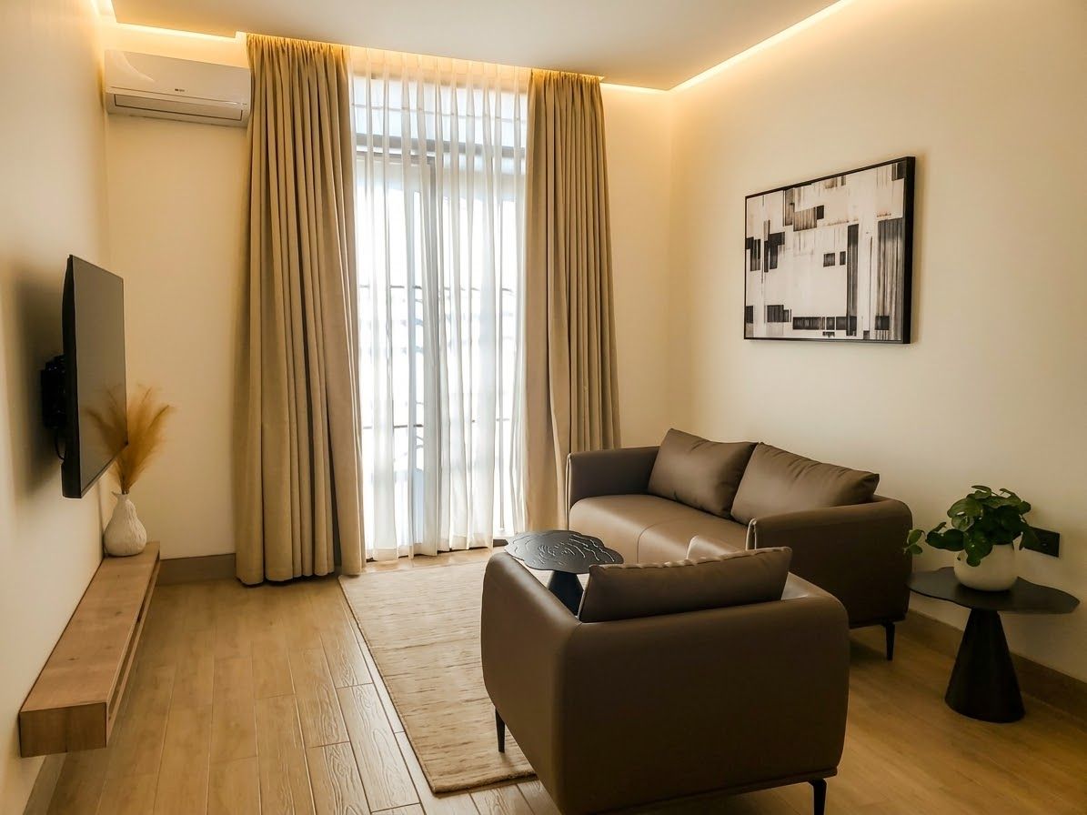 Uma sala de estar moderna com um sofá, uma mesa de centro e uma televisão de tela plana.