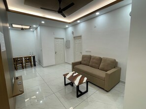 Uma sala de estar moderna com um sofá, uma mesa de centro e um ventilador de teto.