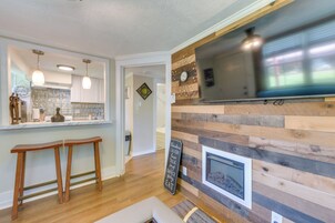 Cozinha moderna com detalhes em madeira, micro-ondas embutido e um quadro negro.