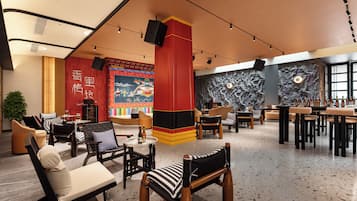 Uma área de estar moderna com disposição de assentos, um bar e elementos decorativos.