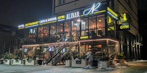 Um edifício com vários andares, com academia, café e restaurante no andar térreo.