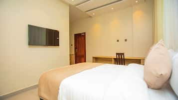 Quarto com cama, escrivaninha e cadeira.