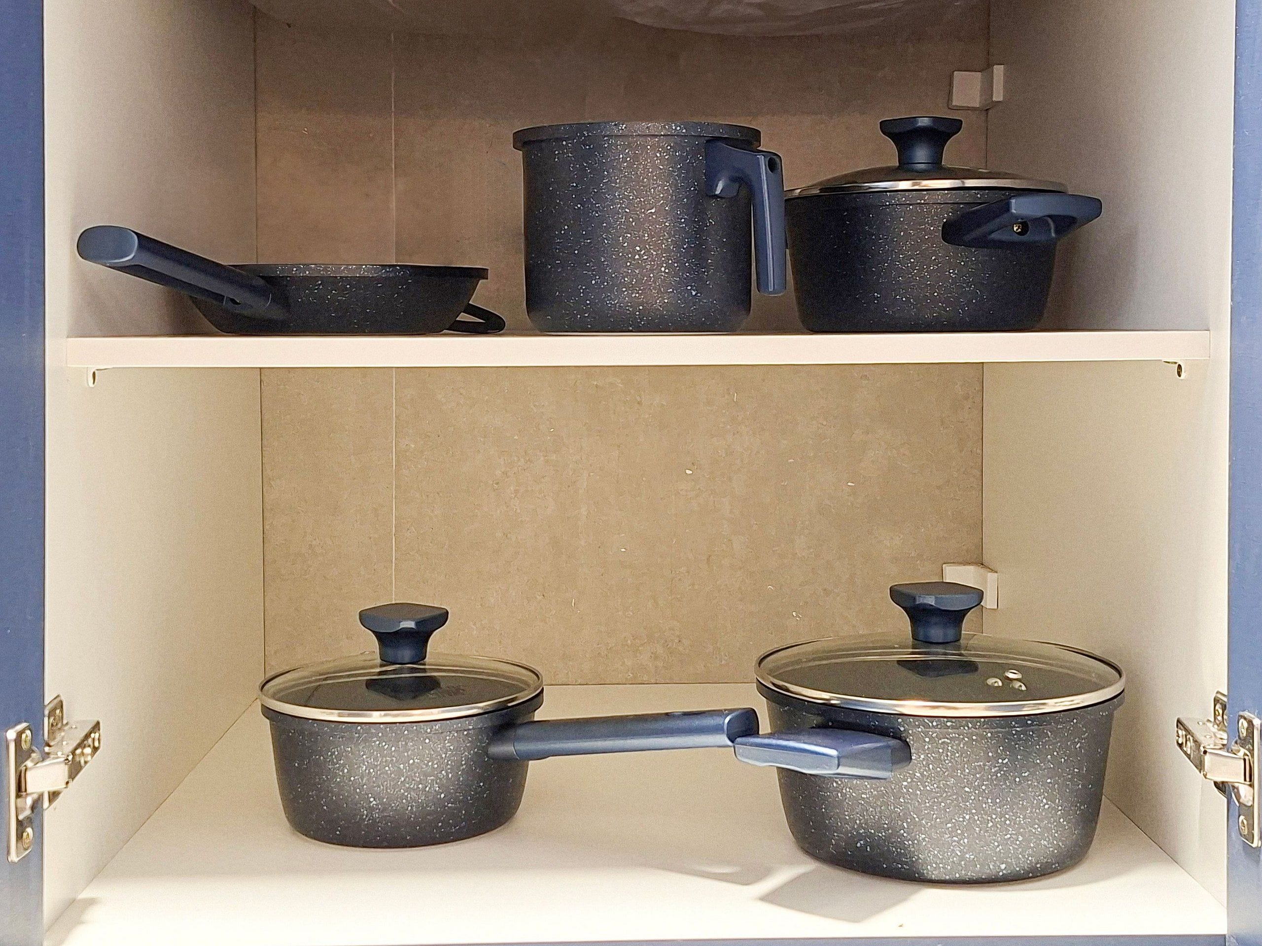Um armário de cozinha com duas prateleiras contendo utensílios de cozinha.