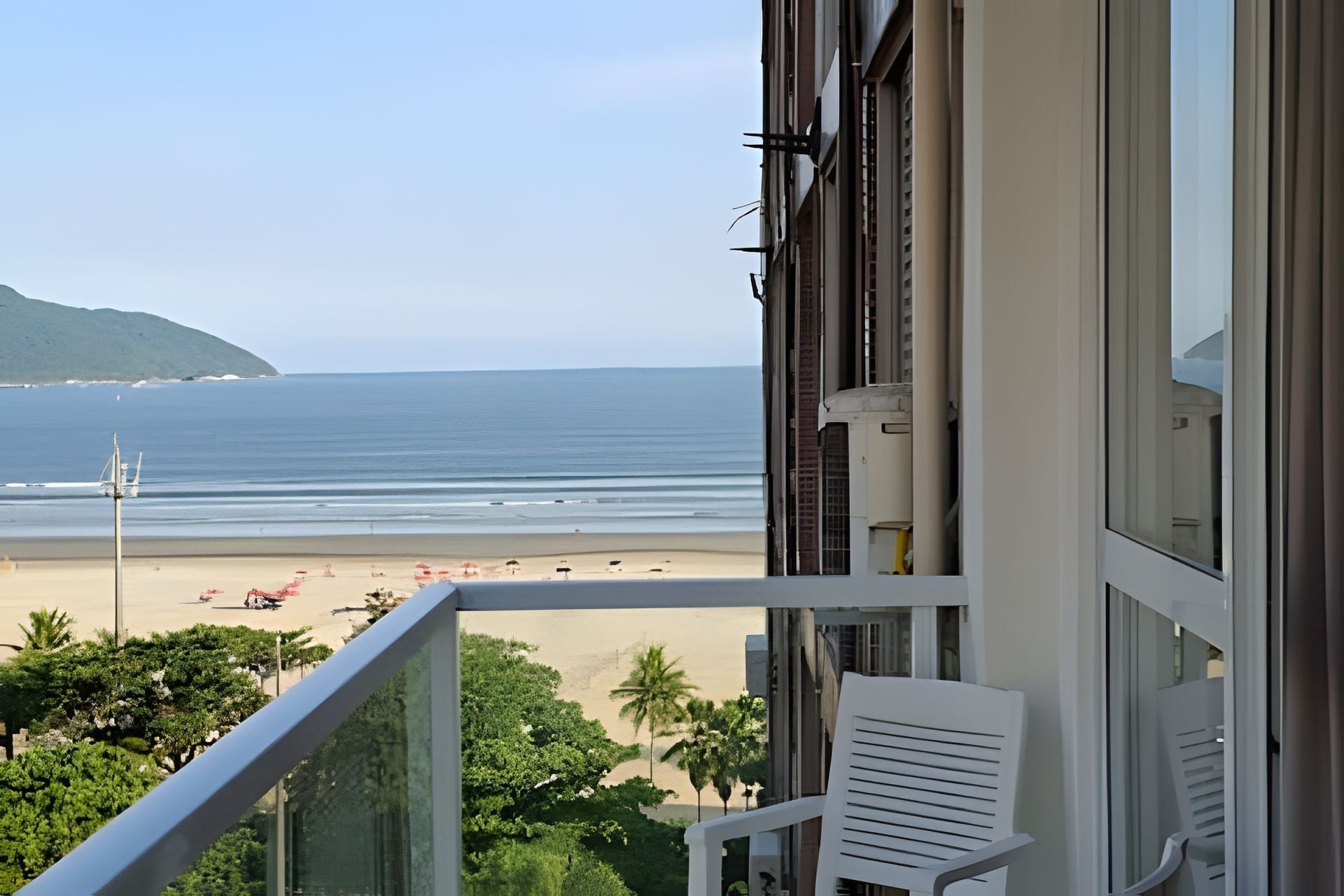 Uma varanda com vista para a praia e o oceano.