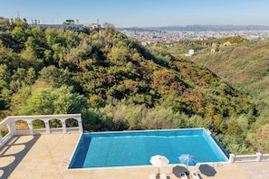 Piscina com vista para o horizonte urbano e colinas.