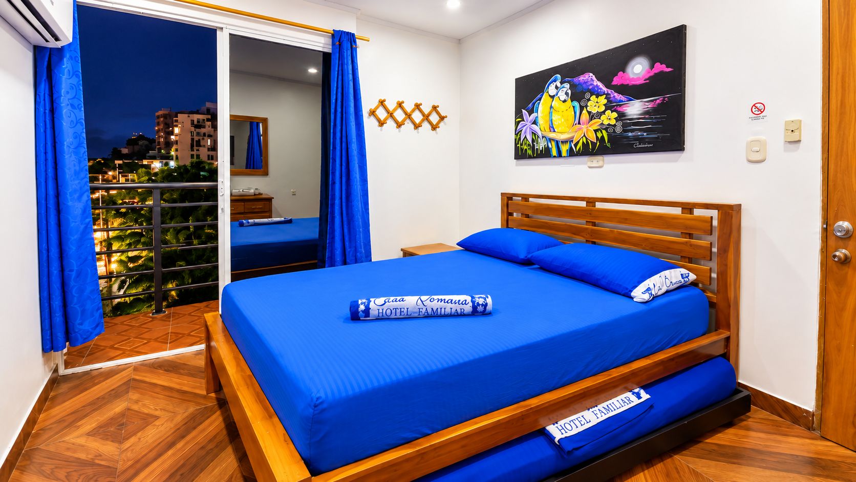 Quarto de hotel com cama, pintura e vista para a cidade.
