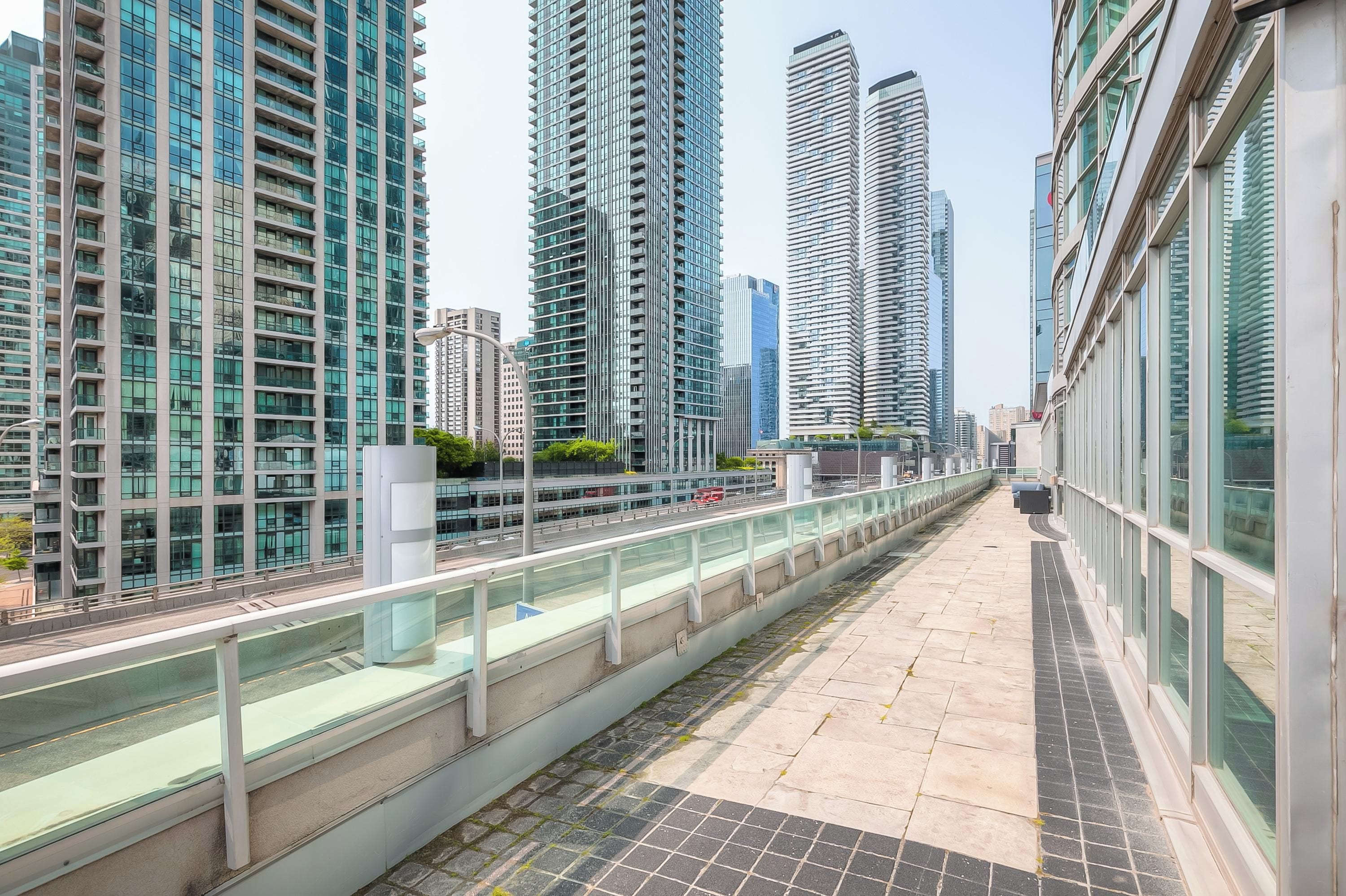 Uma passagem urbana moderna, ladeada por edifícios altos.
