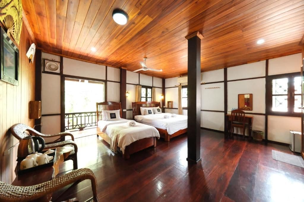 Quarto em estilo japonês tradicional com duas camas, área de jantar e varanda.
