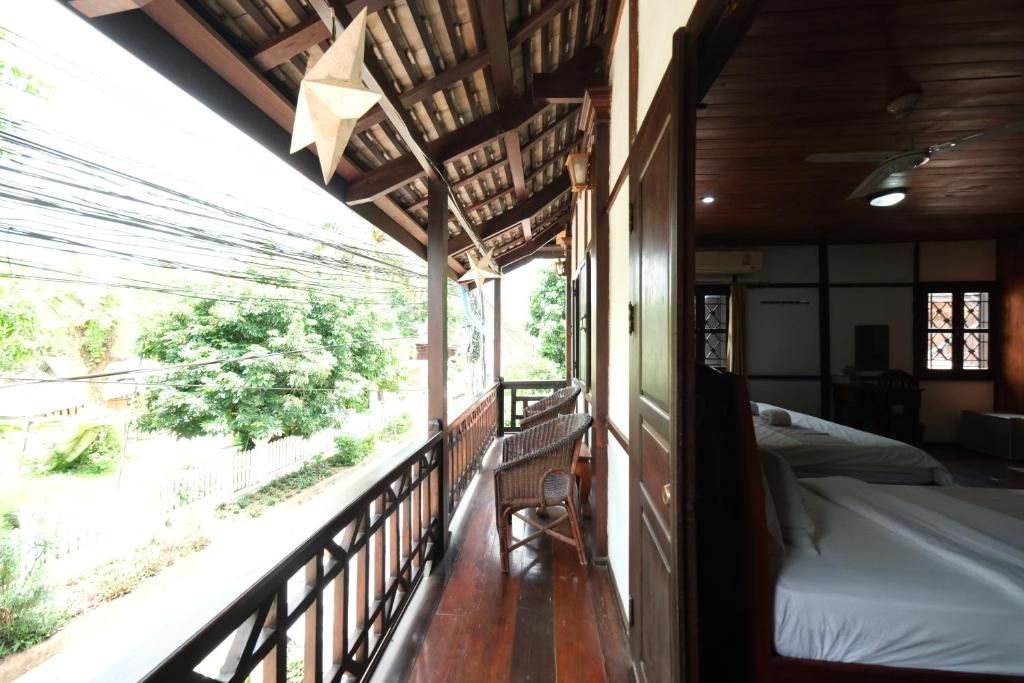 Quarto com varanda, teto de madeira e cama com roupa de cama branca.