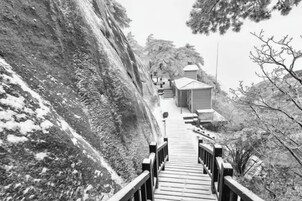 Escadaria de madeira que sobe uma colina, com um pequeno edifício no topo.
