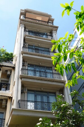 Um edifício com vários andares, varandas e janelas.