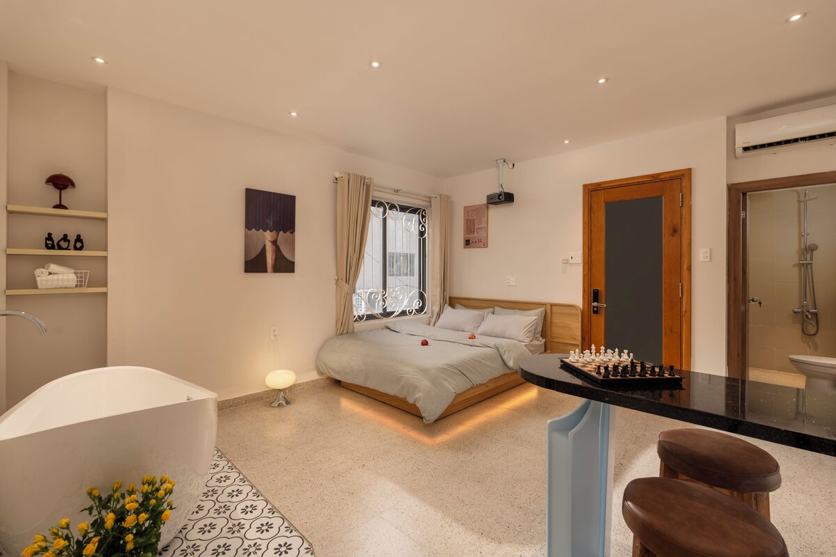 Quarto com cama, escrivaninha e xadrez, chuveiro e banheiro.