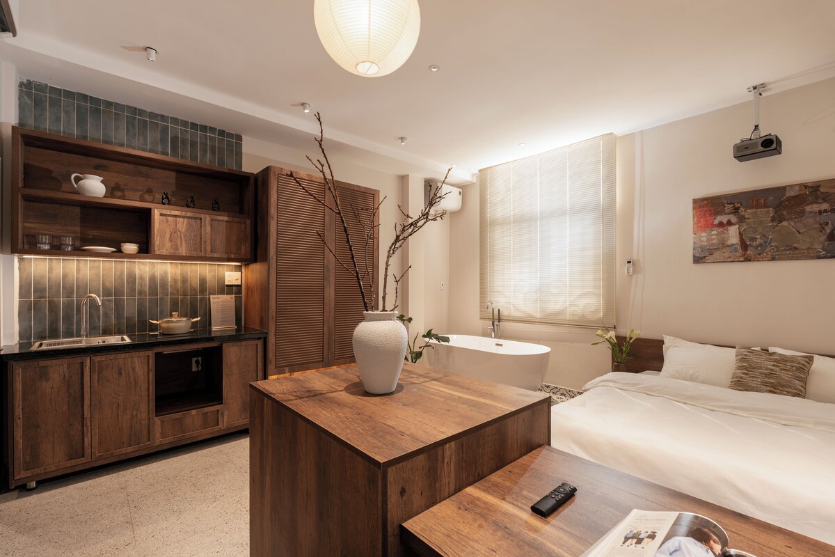 Uma sala de estar moderna com uma mesa de centro de madeira, um sofá branco e uma janela grande com persianas.