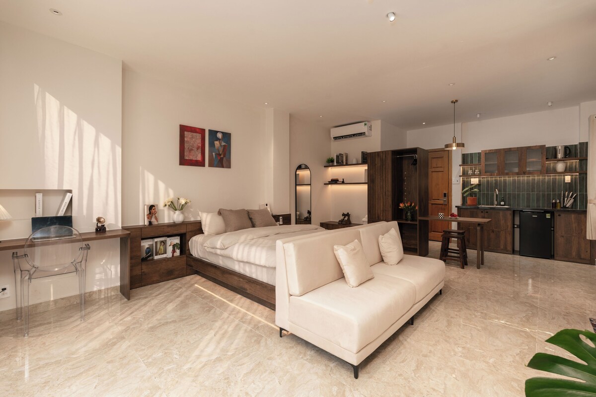 Quarto moderno com uma cama grande, uma escrivaninha e uma kitchenette.