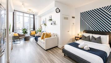 Quarto moderno com uma cama grande, um sofá e uma área de refeições.