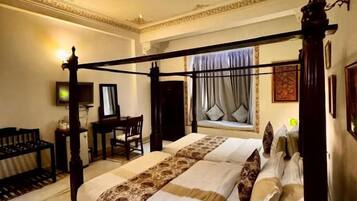 Uma cama com dossel e cortina, um ventilador de teto e um candelabro.