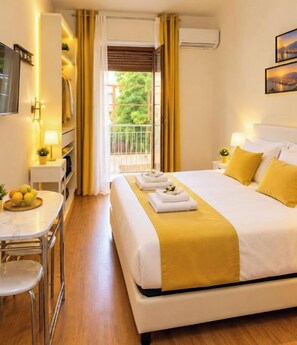 Quarto de hotel com cama, mesas de cabeceira, escrivaninha e varanda com cortinas.