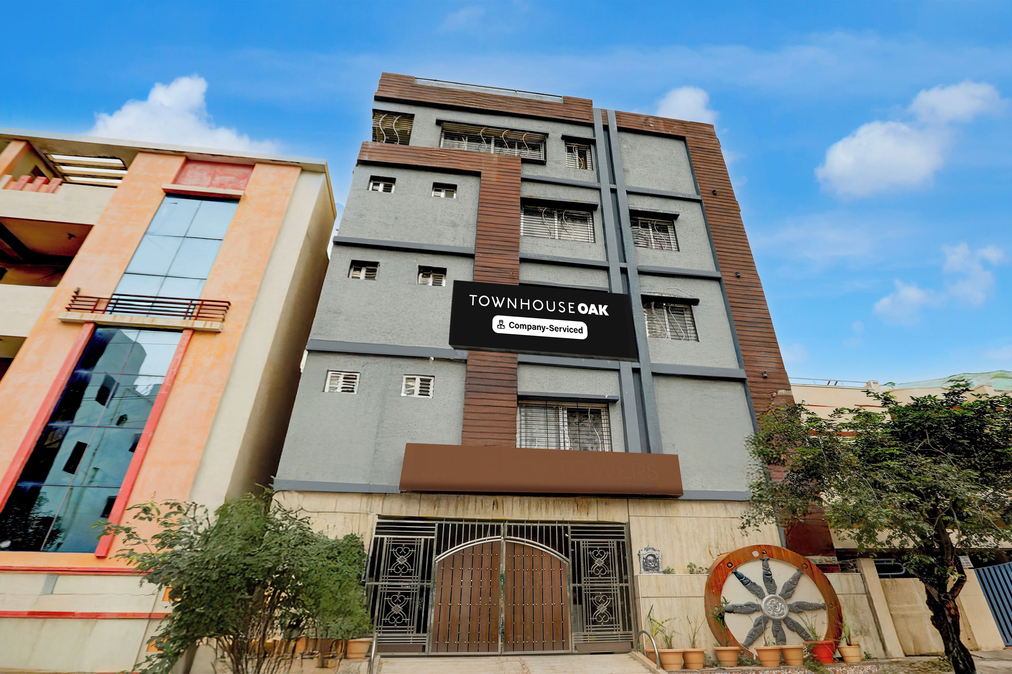 Um edifício de vários andares com uma placa indicando 'TOWNHOUSE OAK' e comodidades oferecidas pela empresa.