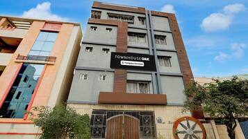 Um edifício de vários andares com uma placa indicando 'TOWNHOUSE OAK' e comodidades oferecidas pela empresa.